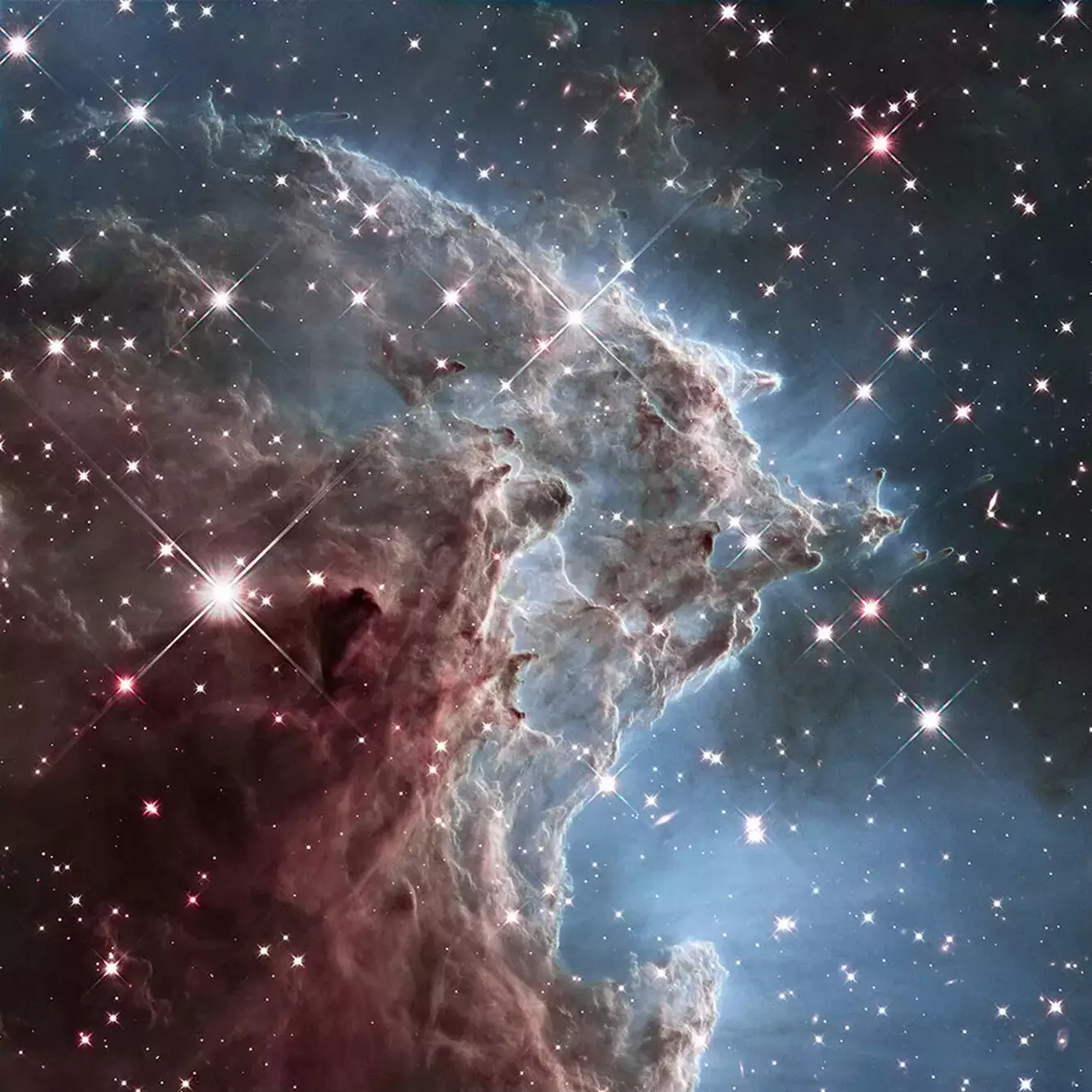 Newborn stars at the center of the Monkey Head Nebula shine through dust clouds