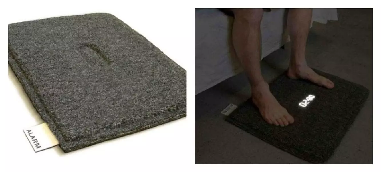 Un espertador en forma de alfombra vella saca fisicamente o propietario da cama. Despois de todo, ata que te pares sobre el cos teus pés, o gadget non parará.