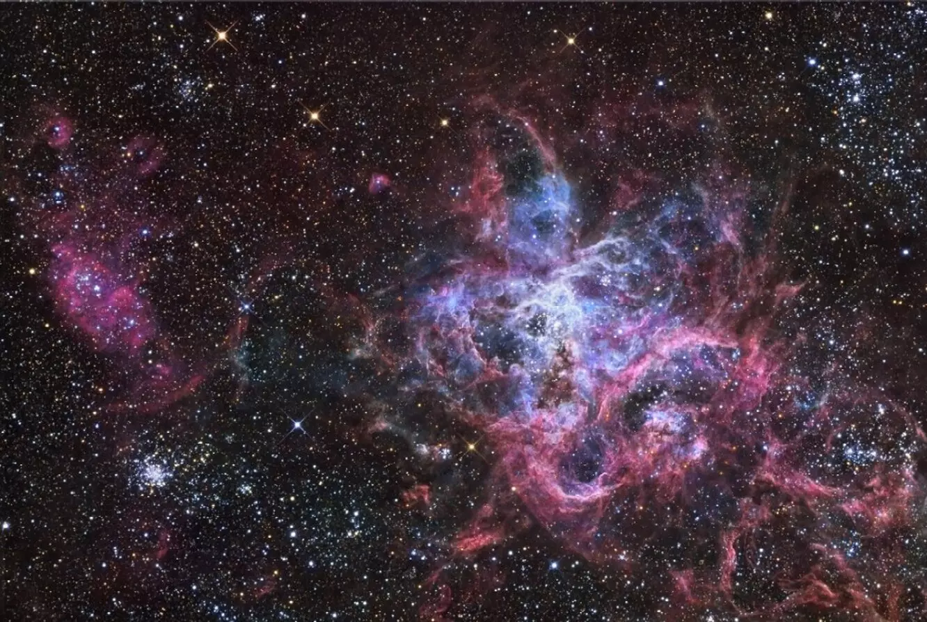 Tarantula Nebula ແມ່ນຫນຶ່ງໃນວັດຖຸທີ່ຫນ້າປະທັບໃຈທີ່ສຸດທີ່ສາມາດສັງເກດເຫັນໄດ້ຈາກຊີກໂລກໃຕ້. Tarantula ແມ່ນ nebula ທີ່ສ້າງເປັນດາວປ່ອຍອາຍພິດທີ່ຕັ້ງຢູ່ໃນກຸ່ມດາວ Doradus ຂອງກາລັກຊີຂະຫນາດໃຫຍ່ Magellanic Cloud. ຂະຫນາດຂອງມັນແມ່ນພຽງແຕ່ເຮັດໃຫ້ປະລາດ. ຖ້າມັນມາຈາກໂລກໃນໄລຍະຫ່າງຂອງ Helix Nebula, ມັນຈະກວມເອົາເຄິ່ງຫນຶ່ງຂອງທ້ອງຟ້າ, ຈາກຈຸດສູງສຸດໄປຫາຂອບຟ້າ.