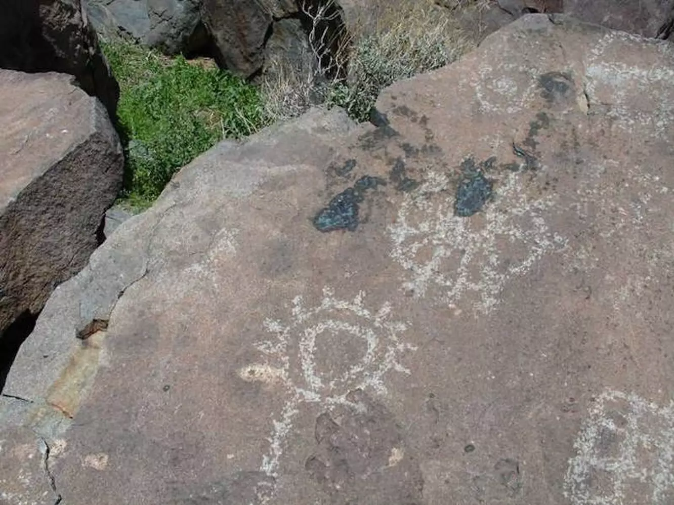 I gceantar an taiscumar is mó sna Stáit Aontaithe - Lake Mead - tá séadchomharthaí naofa de na treibheanna Indiacha a chónaigh ann. Tá siad cláraithe ar Chlár Náisiúnta na Stát Aontaithe um Áiteanna Stairiúla. In 2010, d'úsáid vandal gunna paintball chun péinteáil thar ealaín na carraige. Gabhadh é, cuireadh pianbhreith bliana sa phríosún air, fíneáil $10,000, agus 50 uair de sheirbhís pobail.