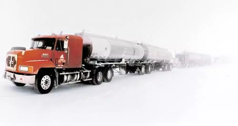 Os trens de estrada diésel para minas de diamantes agardan na fila para cruzar un lago xeado nos Territorios do Noroeste canadense