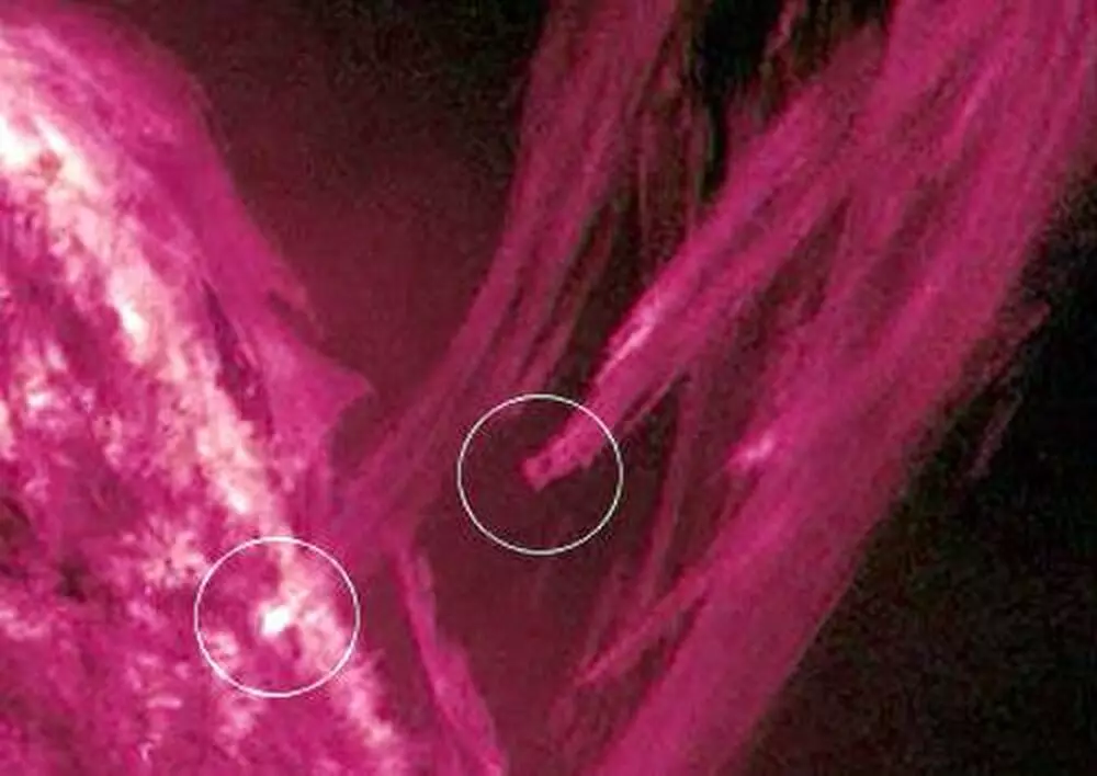 Choiva coronal: 2 fíos de plasma están marcados con círculos, un xa choca contra a superficie do Sol e o segundo segue