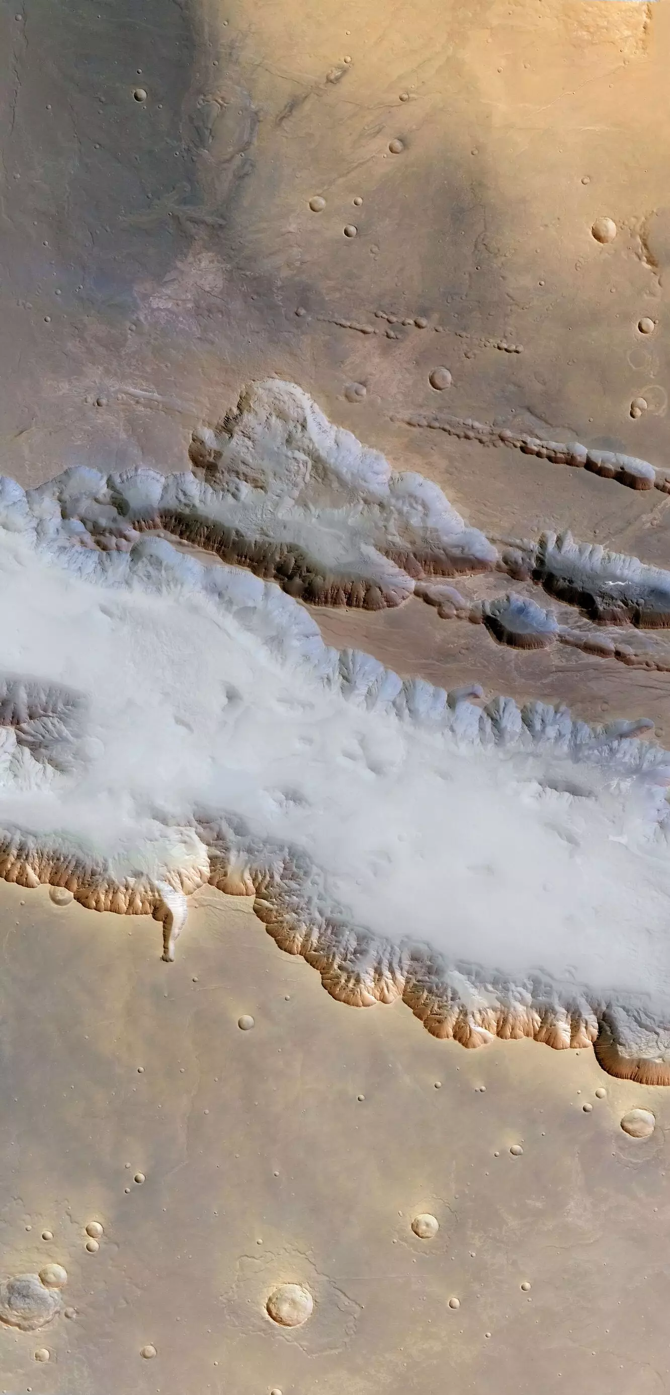 Halimun lebak Mars. Bagian kulon jurang Valles Marines, anu legana 3.060 km, muncul dina poto anu katutupan ku halimun cai sareng kerak és cai isuk. Di sababaraha titik, jero jurang ngahontal 6,5 km, anu langkung ti tilu kali langkung jero tibatan Grand Canyon di Arizona di Bumi.